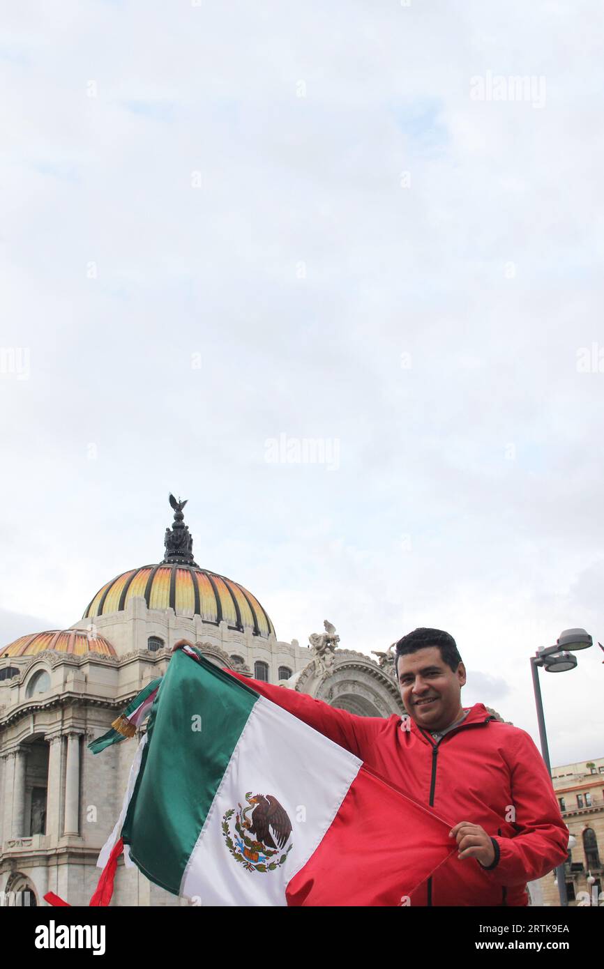 Dark-skinned Latino adult man shows the flag of Mexico proud of his ...