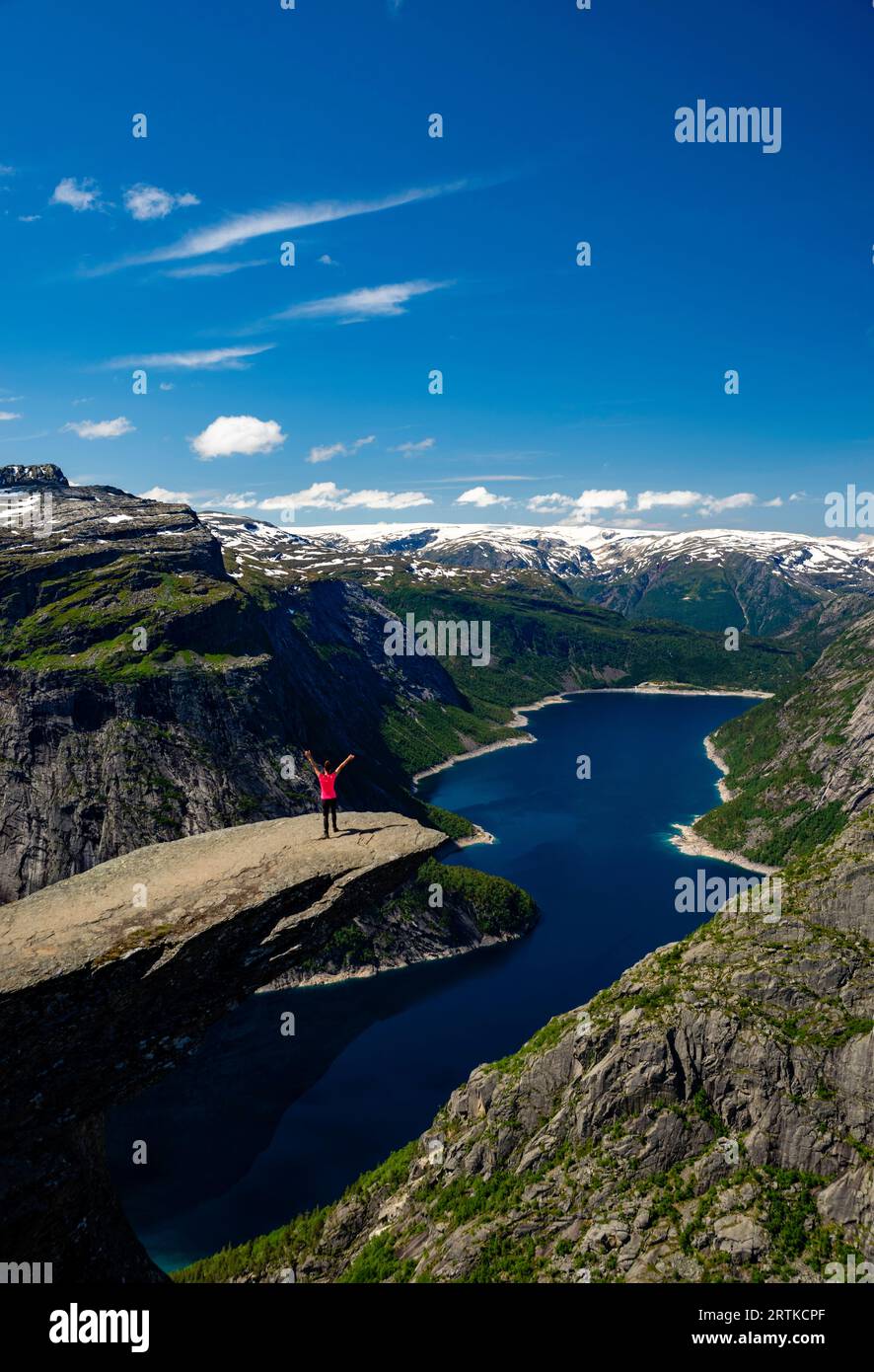 A woman poses on Trolltunga (Troll's Tongue) overlooking ...