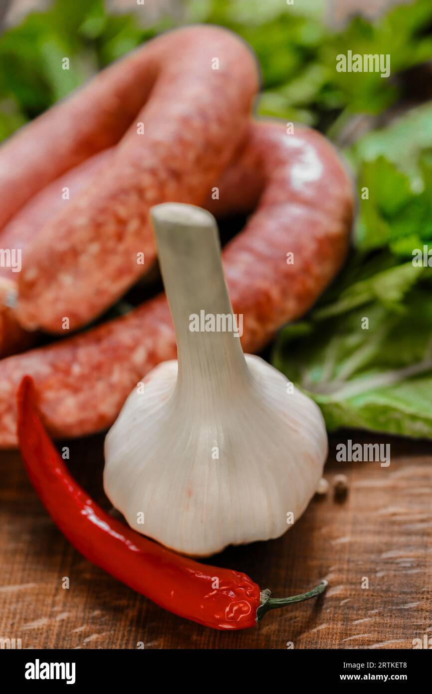 sausages in rustic style.Raw sausage rings, fresh parsley, red chili ...