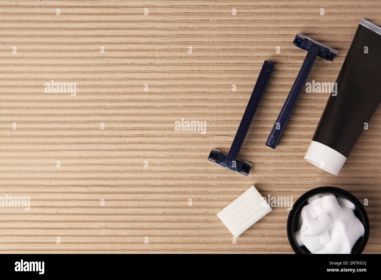 Razors, shaving foam, soap and cream on cardboard, flat lay. Space for ...