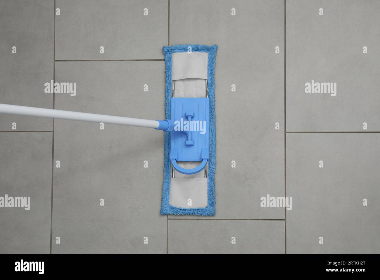 Cleaning grey tiled floor with mop, top view Stock Photo - Alamy
