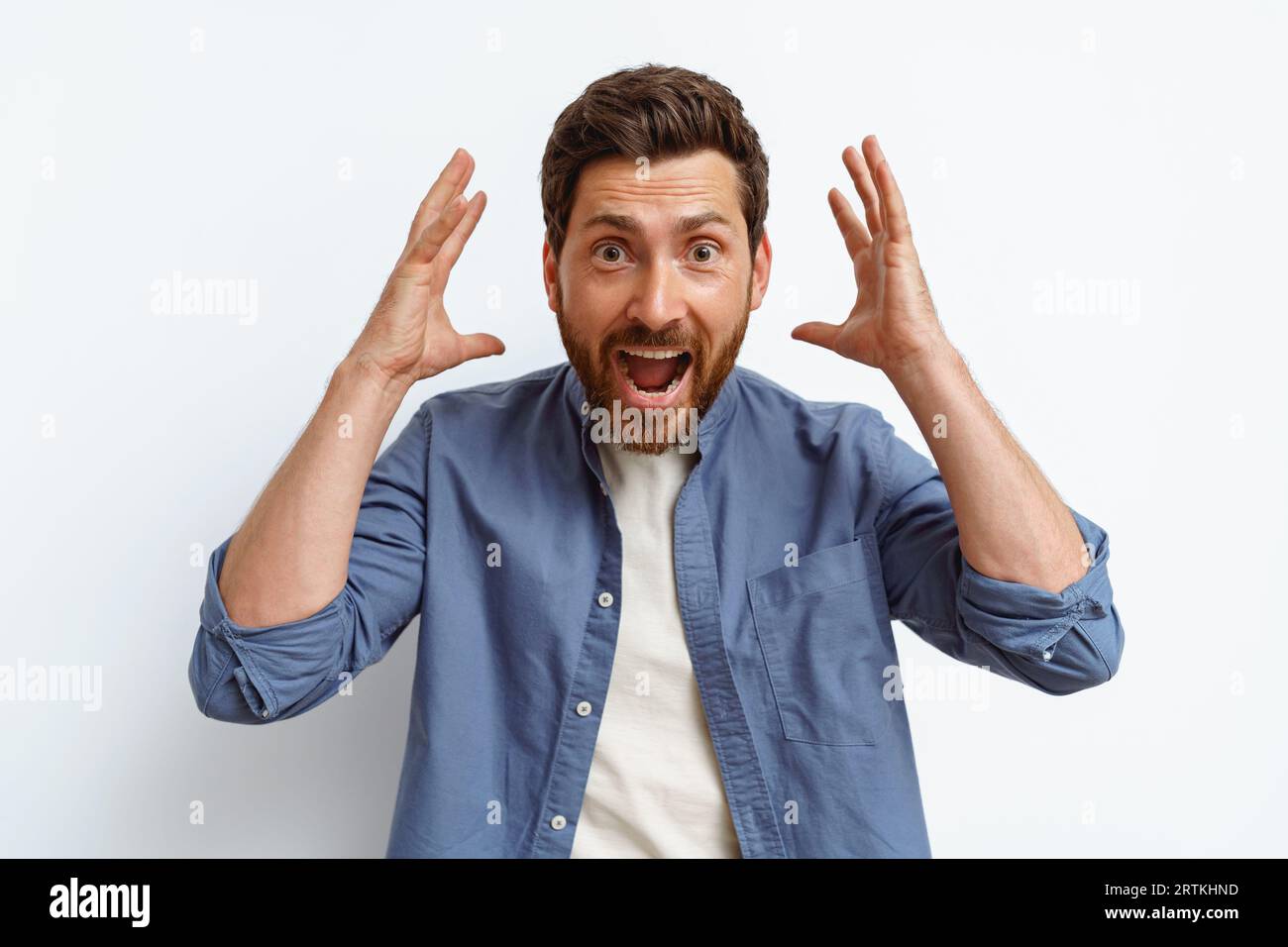 Surprised and shocked man standing on white background and screaming ...