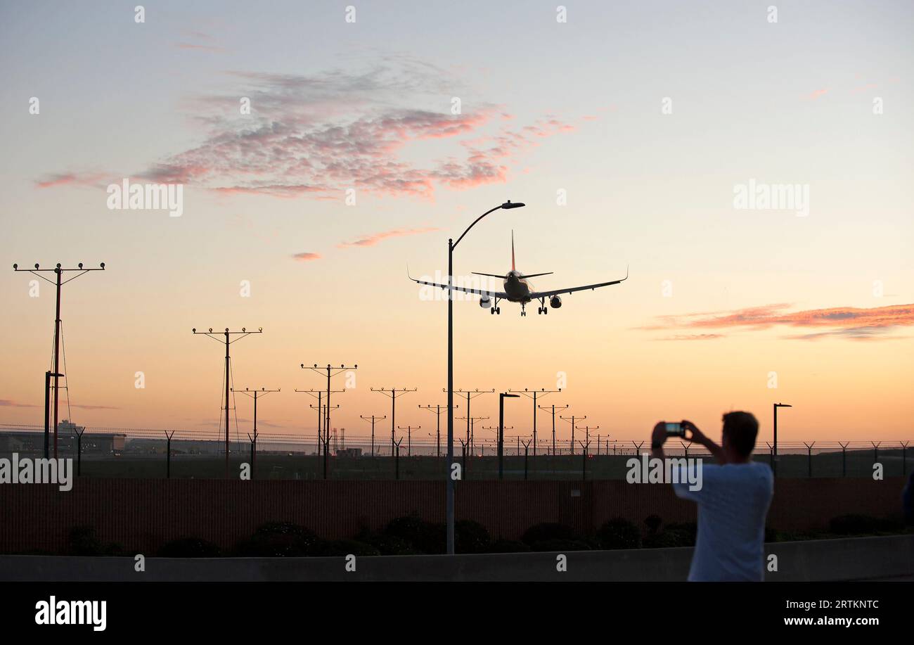Man photographing a plane landing at LAX with a cell phone, Los Angeles ...