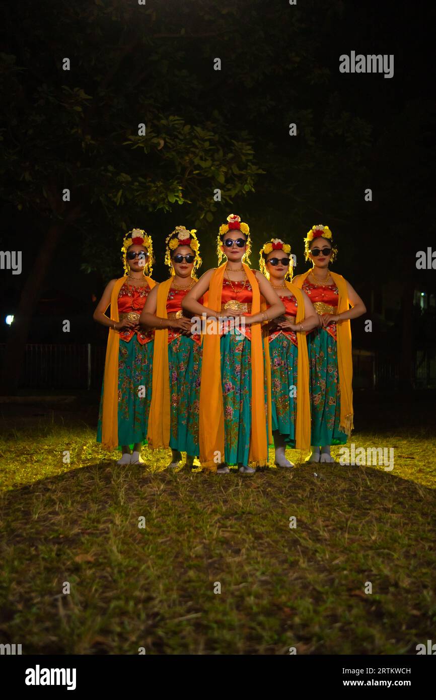 a group of traditional Javanese dancers standing in costumes and orange ...