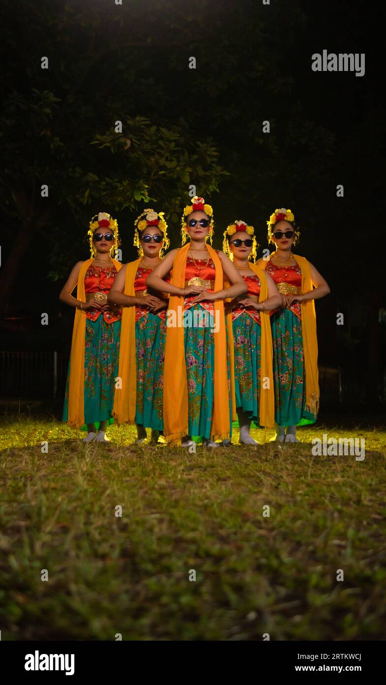 a group of traditional Javanese dancers standing in costumes and orange ...