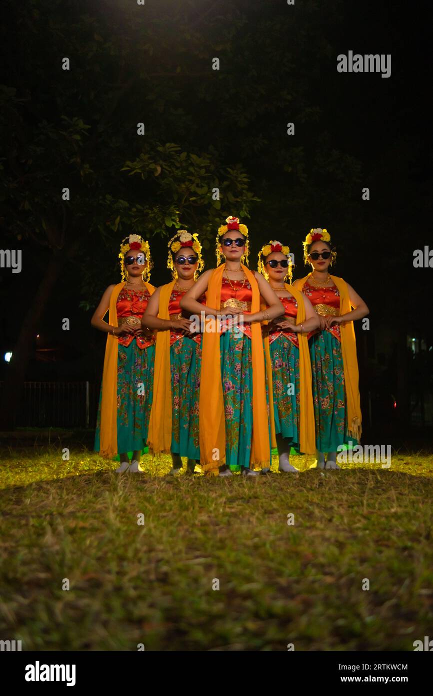 a group of traditional Javanese dancers standing in costumes and orange ...