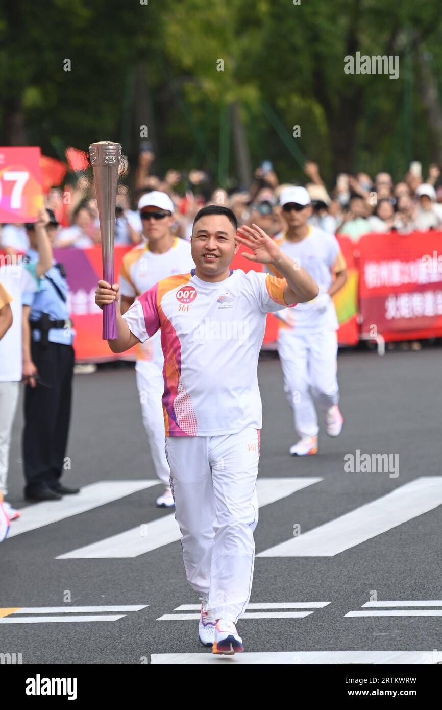 Taizhou, China's Zhejiang Province. 14th Sep, 2023. Torch bearer Yang Wenjie runs with the torch ...