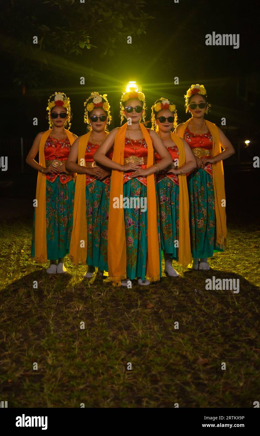 a group of Indonesian traditional dancers dance with their friends in ...