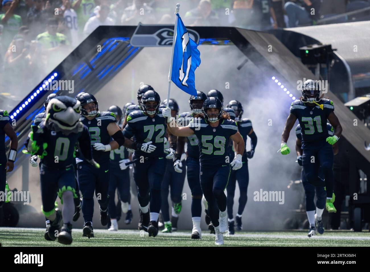 Seattle Seahawks linebacker Jon Rhattigan (59) carries the 12th man ...