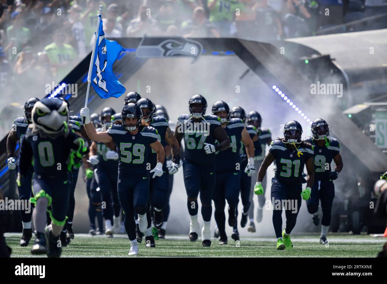 Seattle Seahawks linebacker Jon Rhattigan (59) carries the 12th man ...