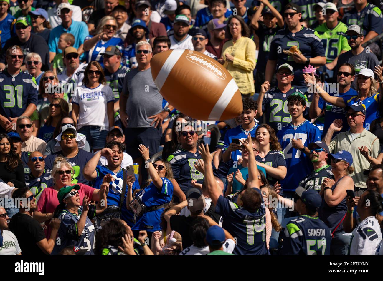 Fans pass around an inflatable football during an NFL football game ...
