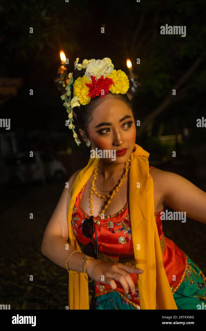portrait of a traditional Sundanese dancer dancing with an orange scarf ...