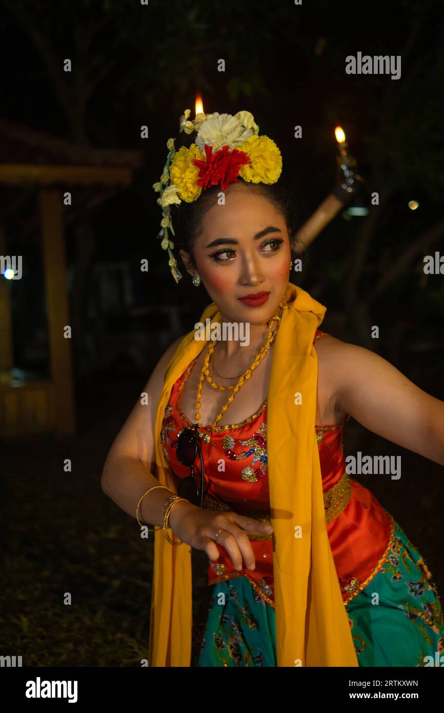 portrait of a traditional Sundanese dancer dancing with an orange scarf ...