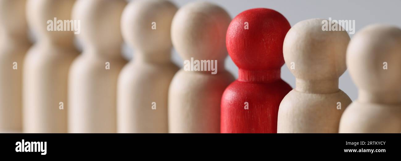 Red figure in row of many common wooden people figures Stock Photo - Alamy