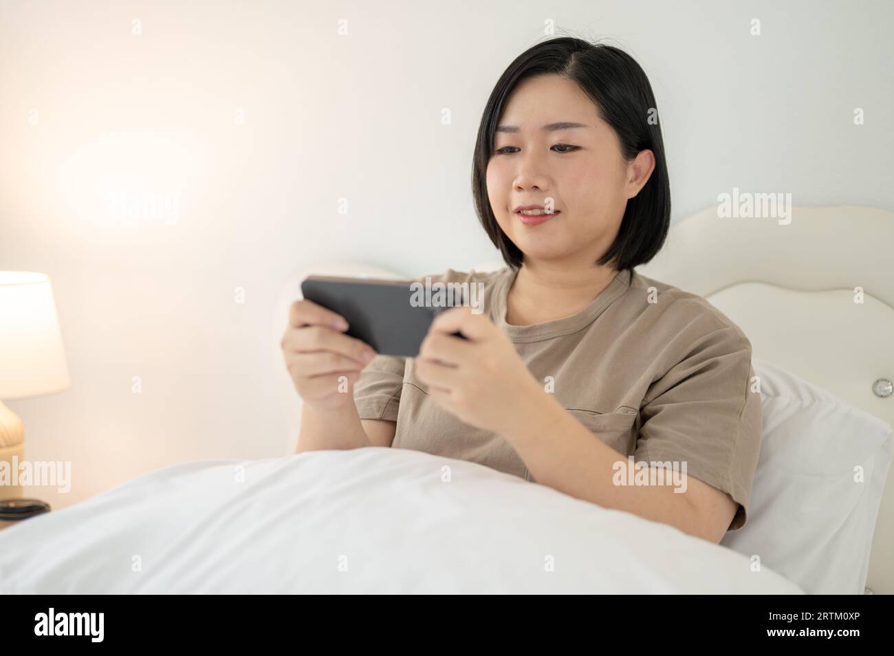 A beautiful and happy Asian plus-size woman in comfy clothes enjoys ...