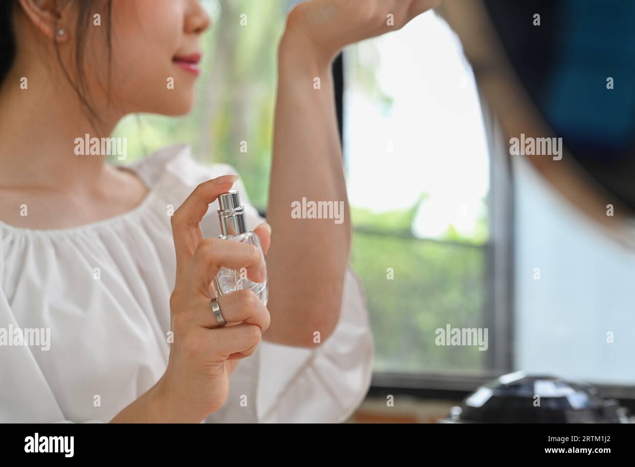 Young woman beauty blogger spraying perfume on her wrist while ...