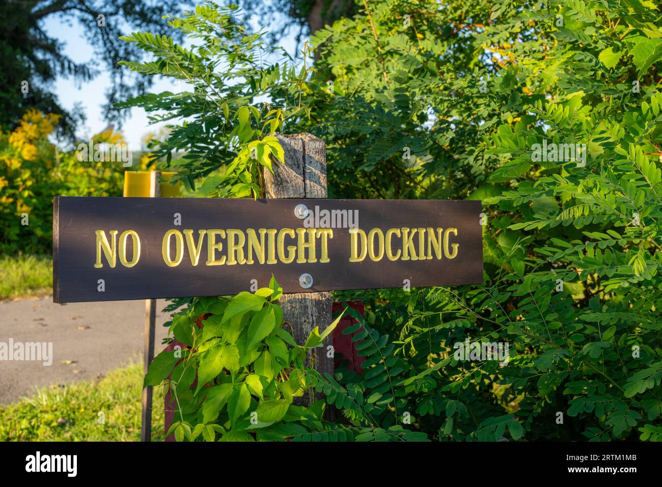 Weathered brown and gold wood sign on post, NO OVERNIGHT DOCKING Stock ...
