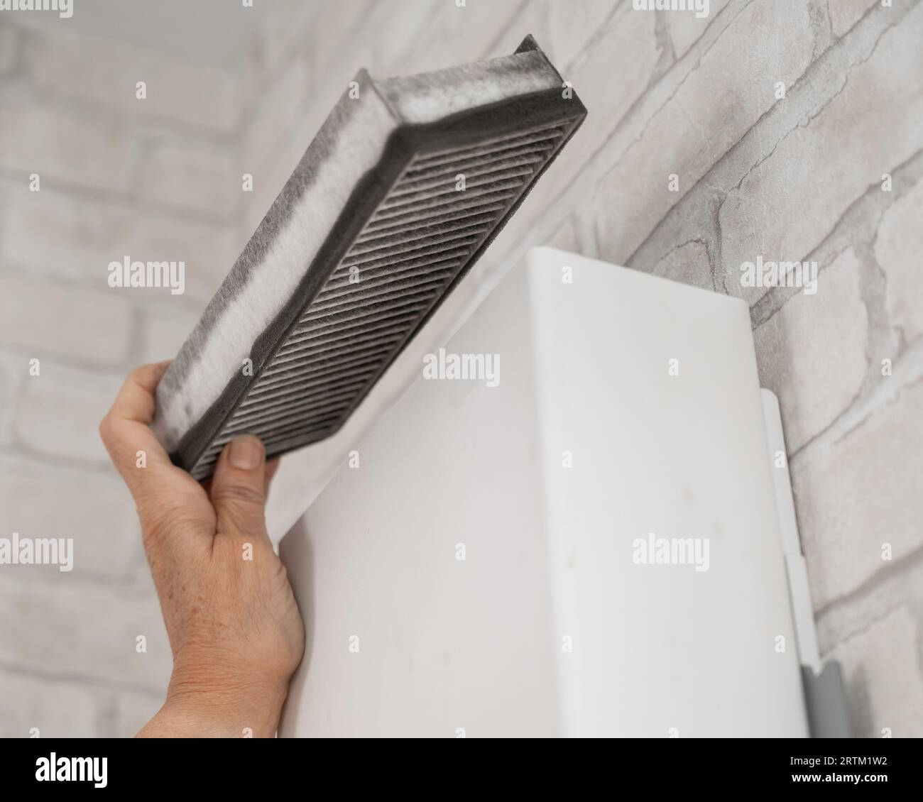 A man changes the filter at the supply ventilation. Gadget for ...