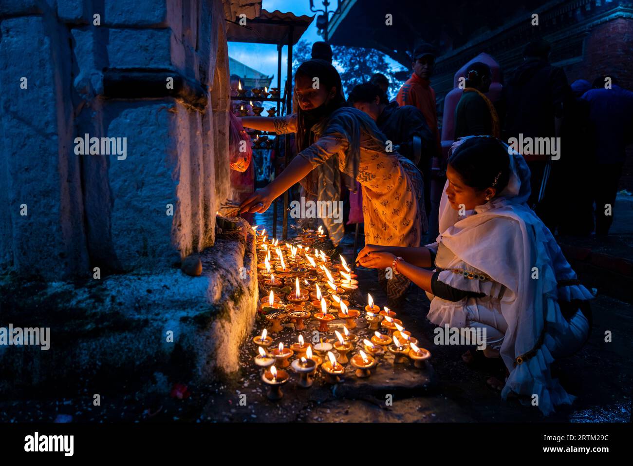 A Nepalese devotee lights an oil lamp during Kuse Aunsi festival at the ...
