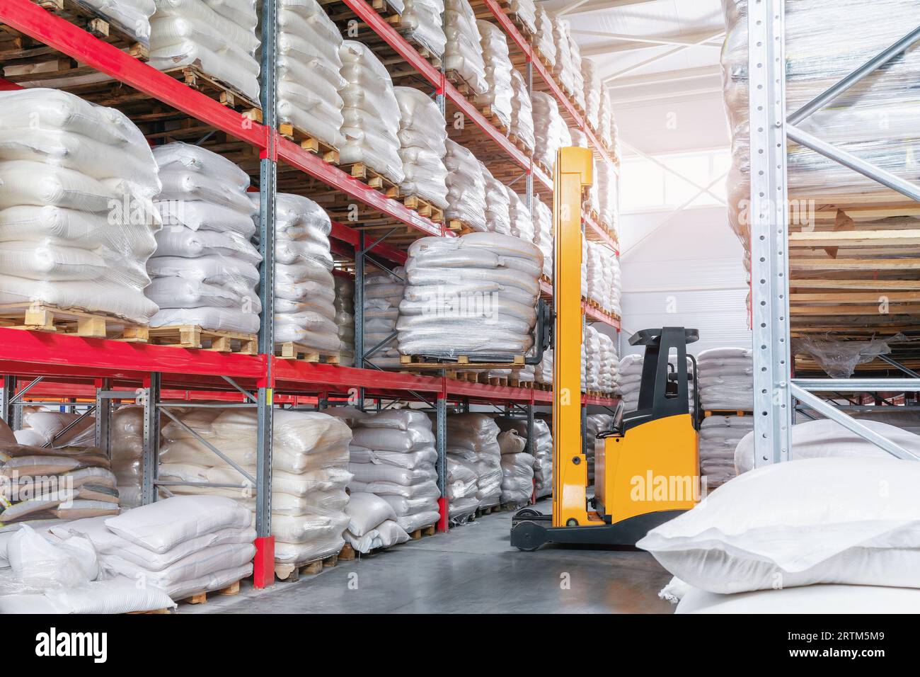 Forklift in a food warehouse loading goods on a rack Stock Photo - Alamy