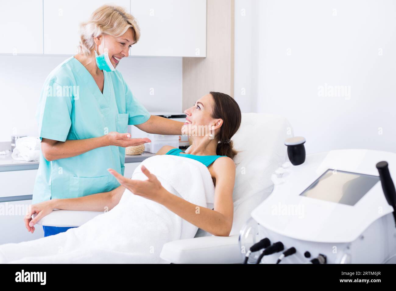 Cosmetician explaining treatment to patient Stock Photo - Alamy