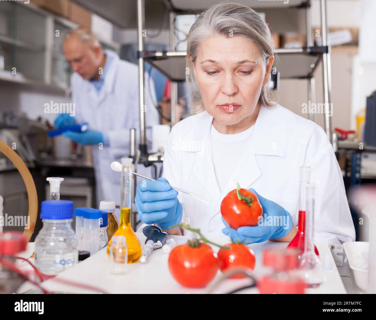 Female geneticist conducting experiments with fruits and vegetables ...