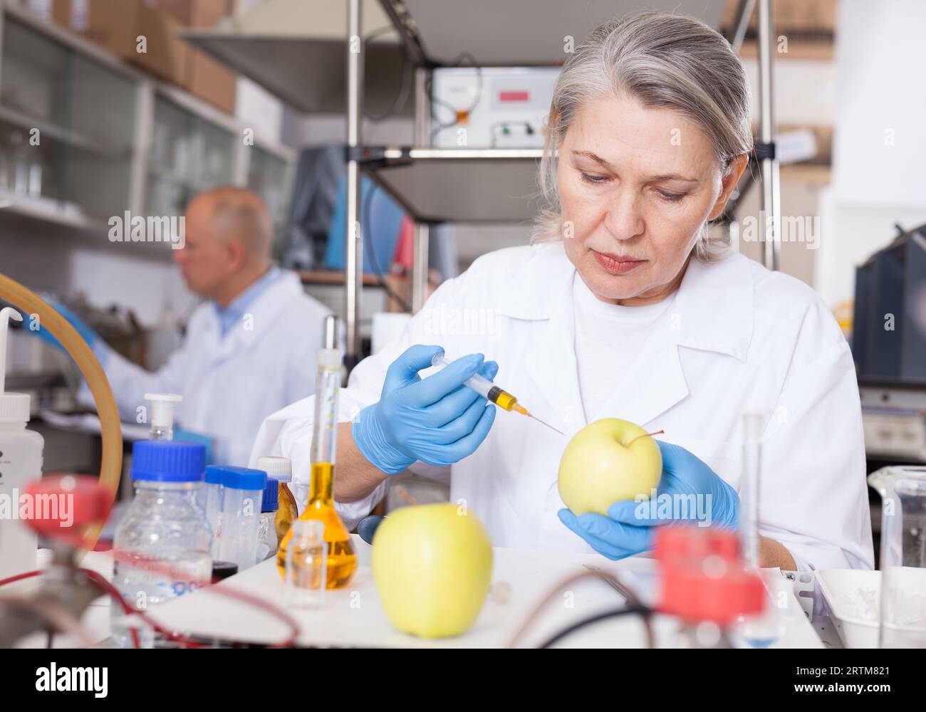 Female scientist injecting reagent into apple Stock Photo - Alamy