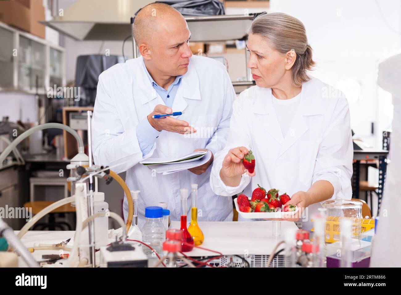 Scientists taking notes while performing experiments Stock Photo - Alamy