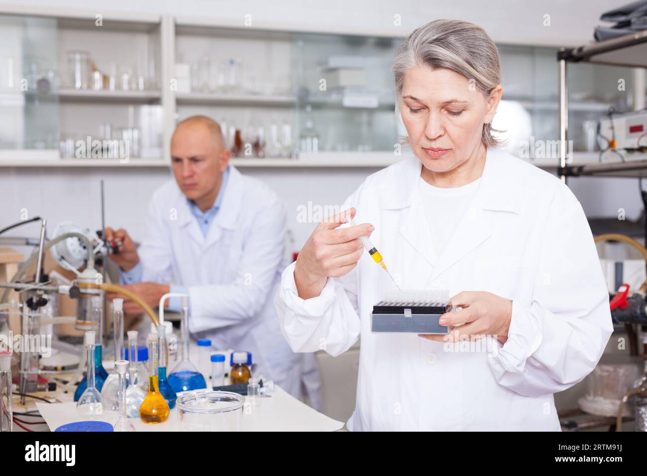 Female chemist mixing chemical agents Stock Photo - Alamy