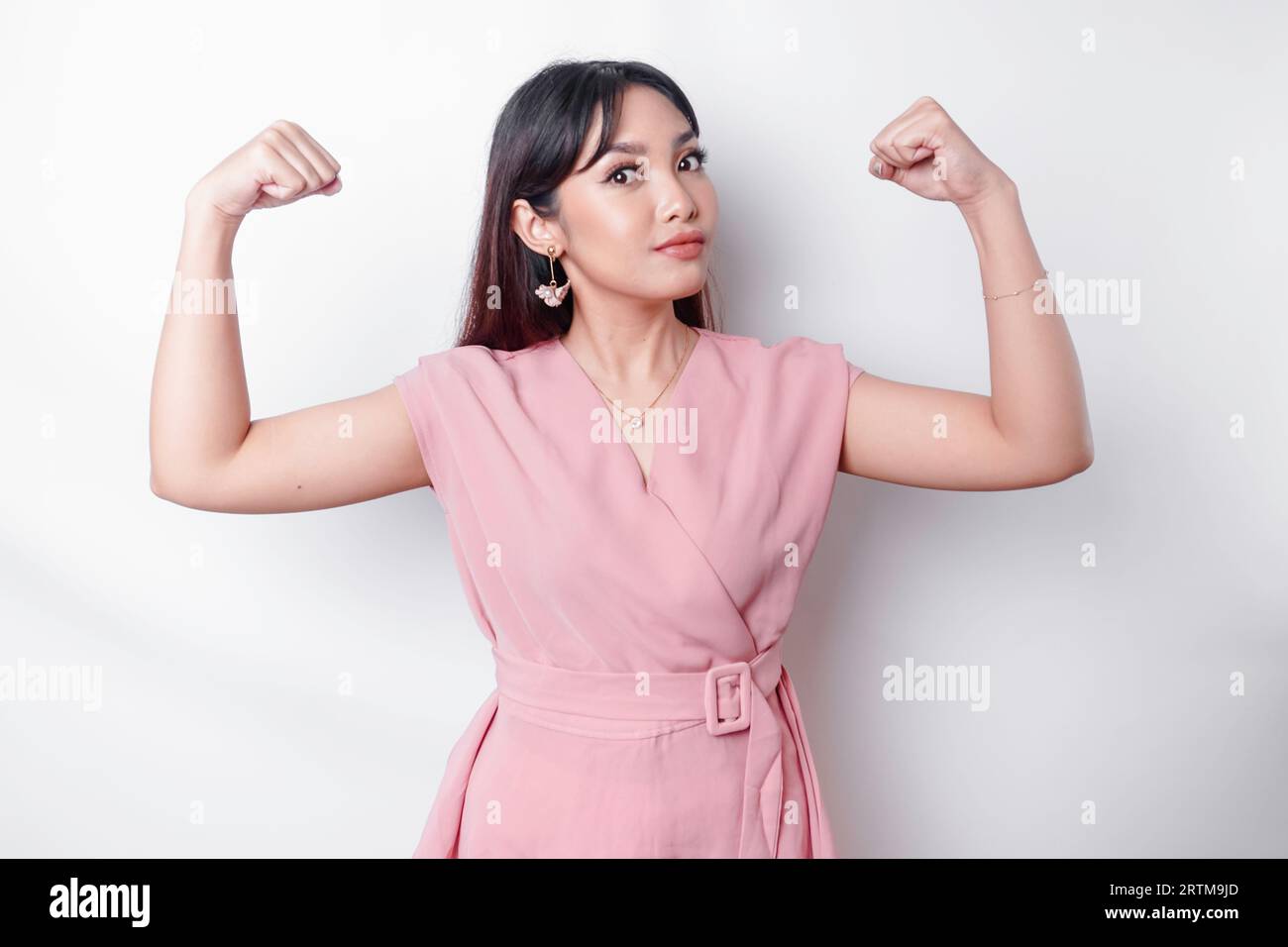 Excited Asian woman wearing a pink blouse showing strong gesture by ...