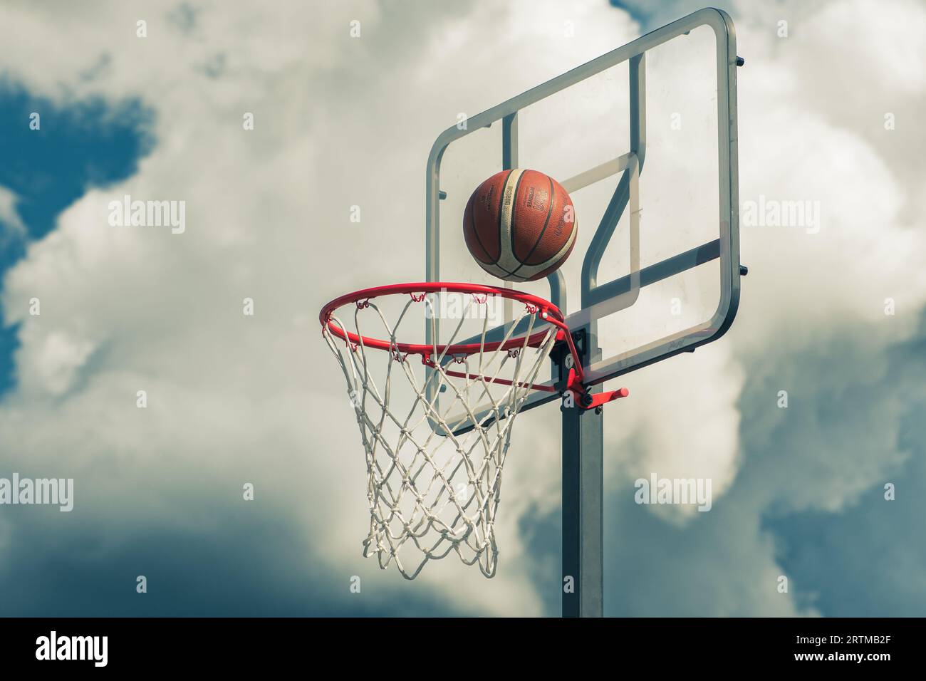 Basketball orange ball is entering the hoop or basket. Playing in the ...