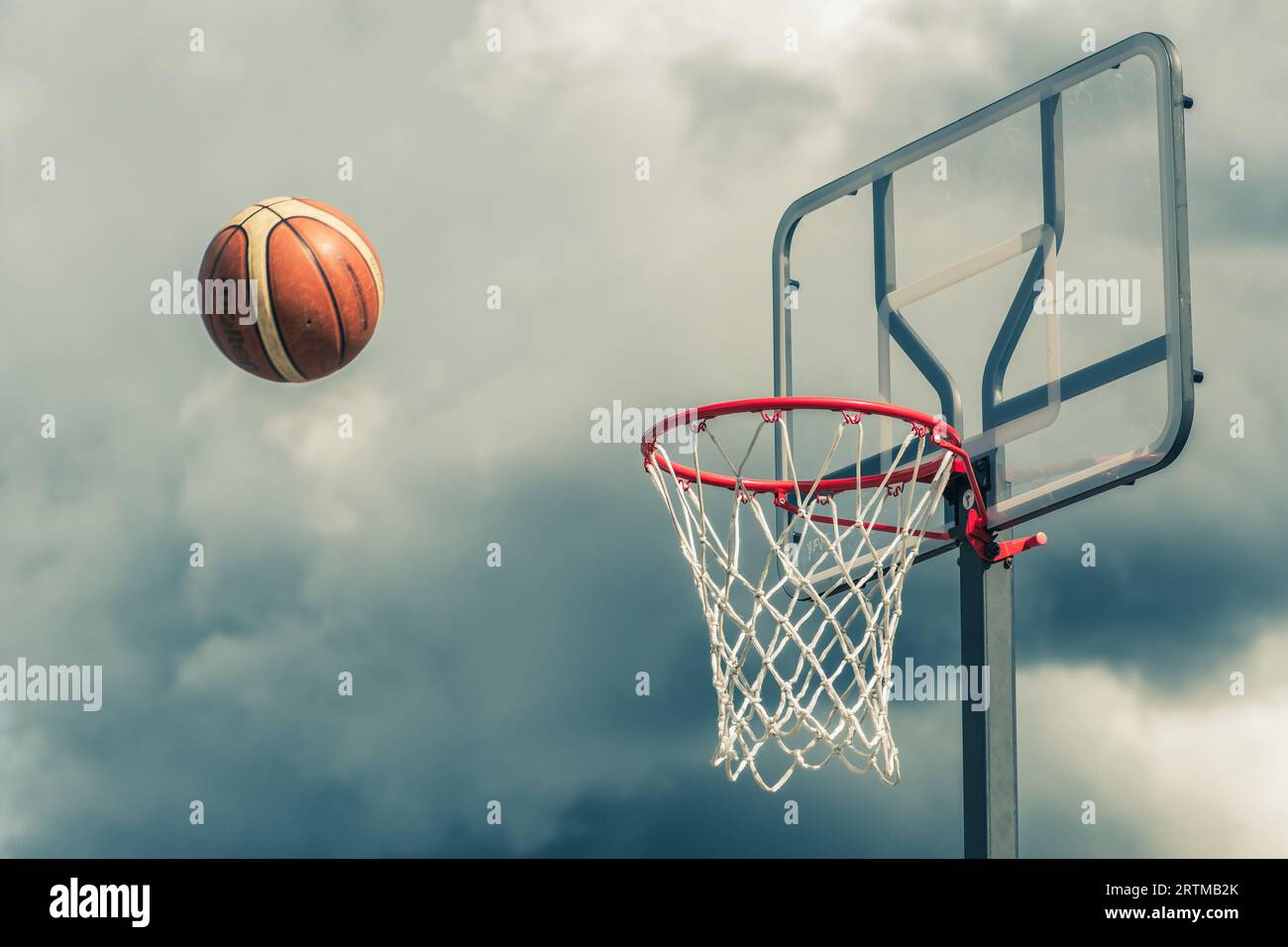 Basketball orange ball is entering the hoop or basket. Playing in the ...