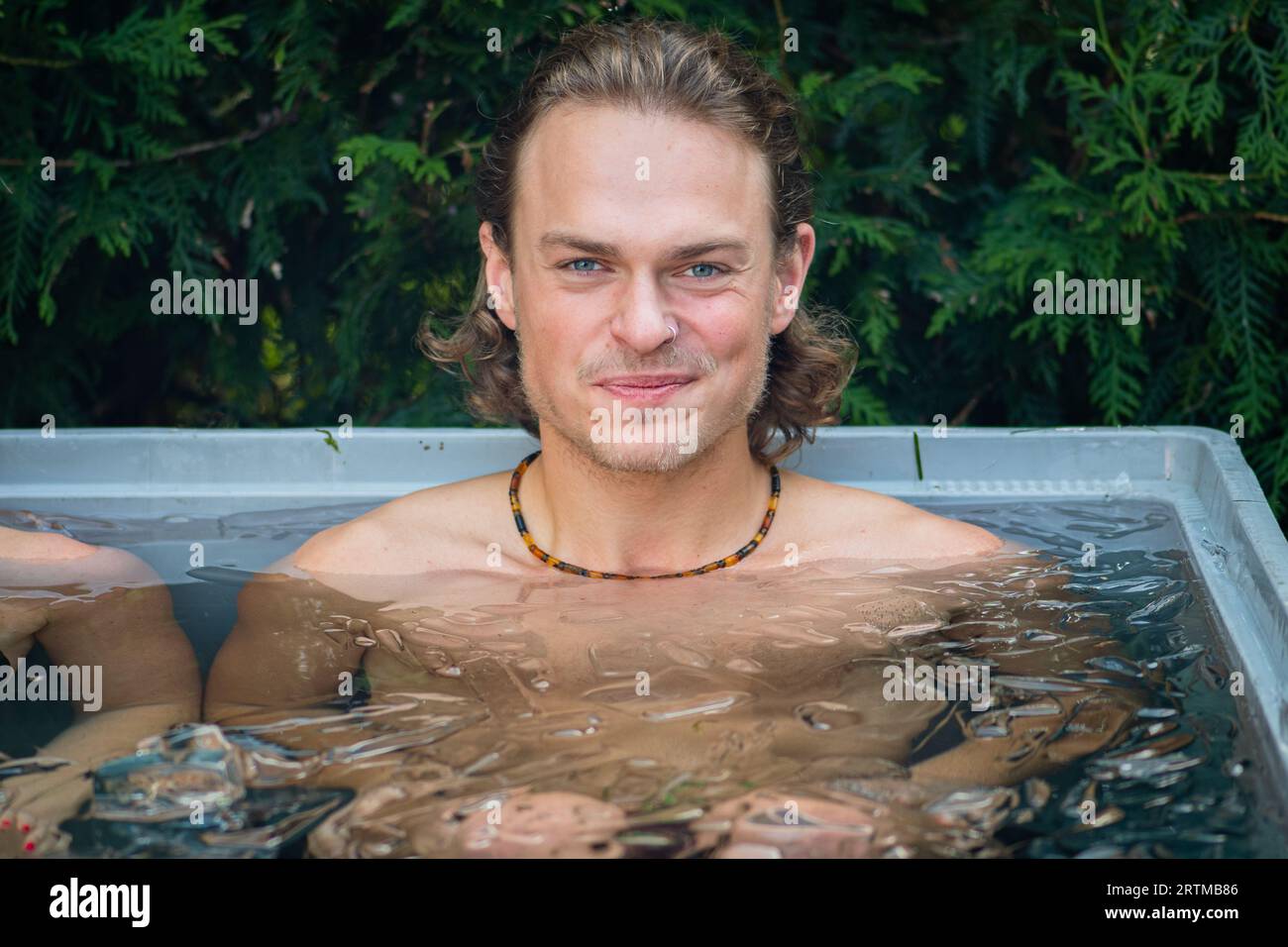 Beautiful boy with closed eyes bathing in the cold water among ice ...