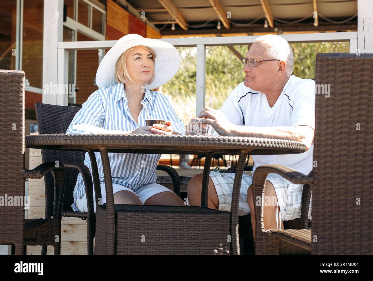 Happy mature middle aged couple talking, woman showing off her hat ...