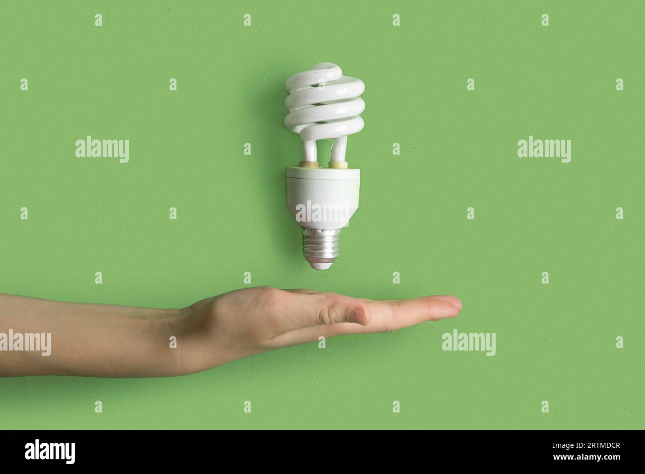 Compact fluorescent lamp Lamp in human hand. Helical integrated CFL ...