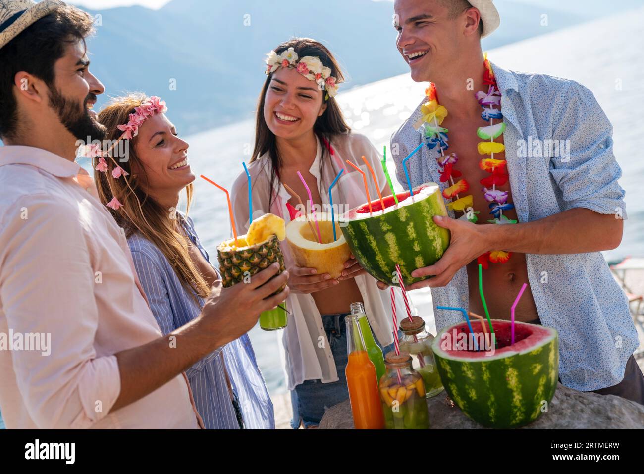 Group of multiethnic friends enjoying Hawaiian party on summer vacation ...