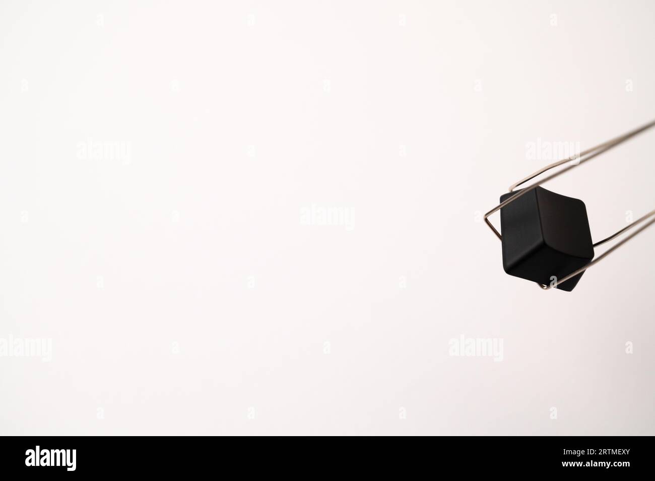 A close-up of a detached mechanical keyboard keycap hanging in a ...