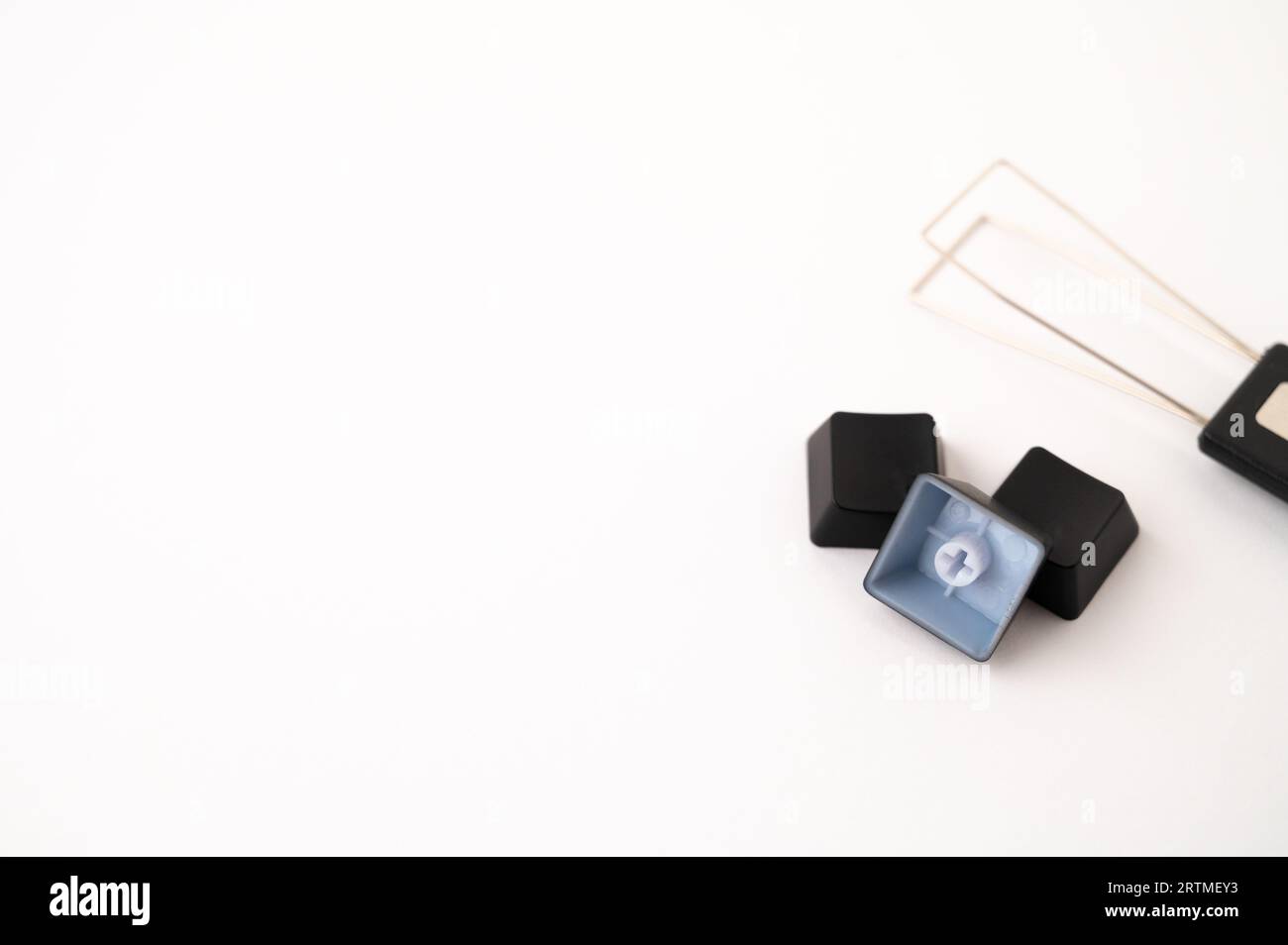 A close-up of a pile of three detached mechanical keyboard keycaps ...