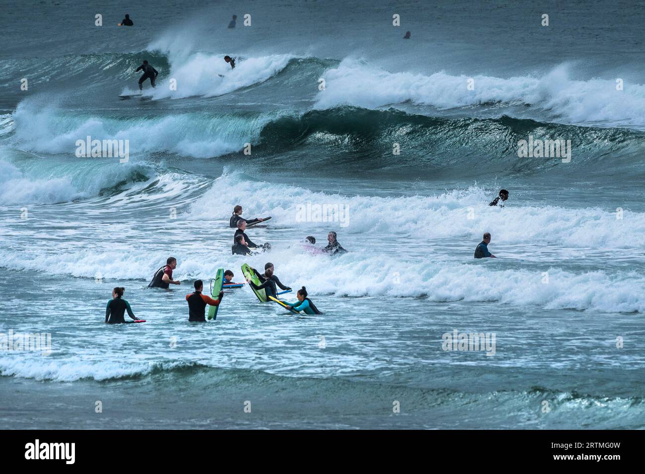Bodyboarders Boogie boarders and surfers in the sea on a cold chilly ...