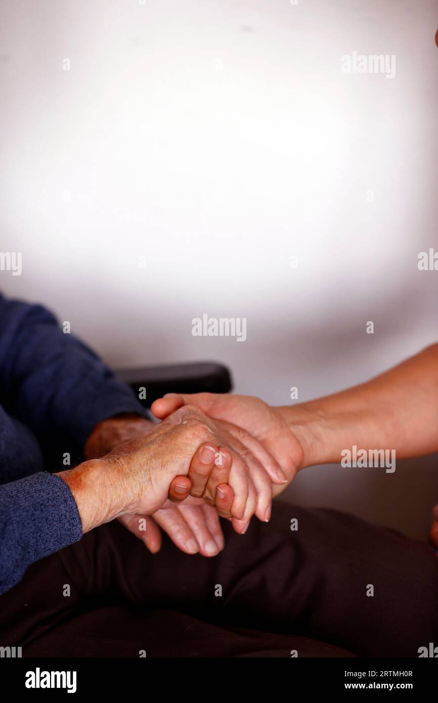 Retirment home. Close up of care assistants hand reassuring senior man ...