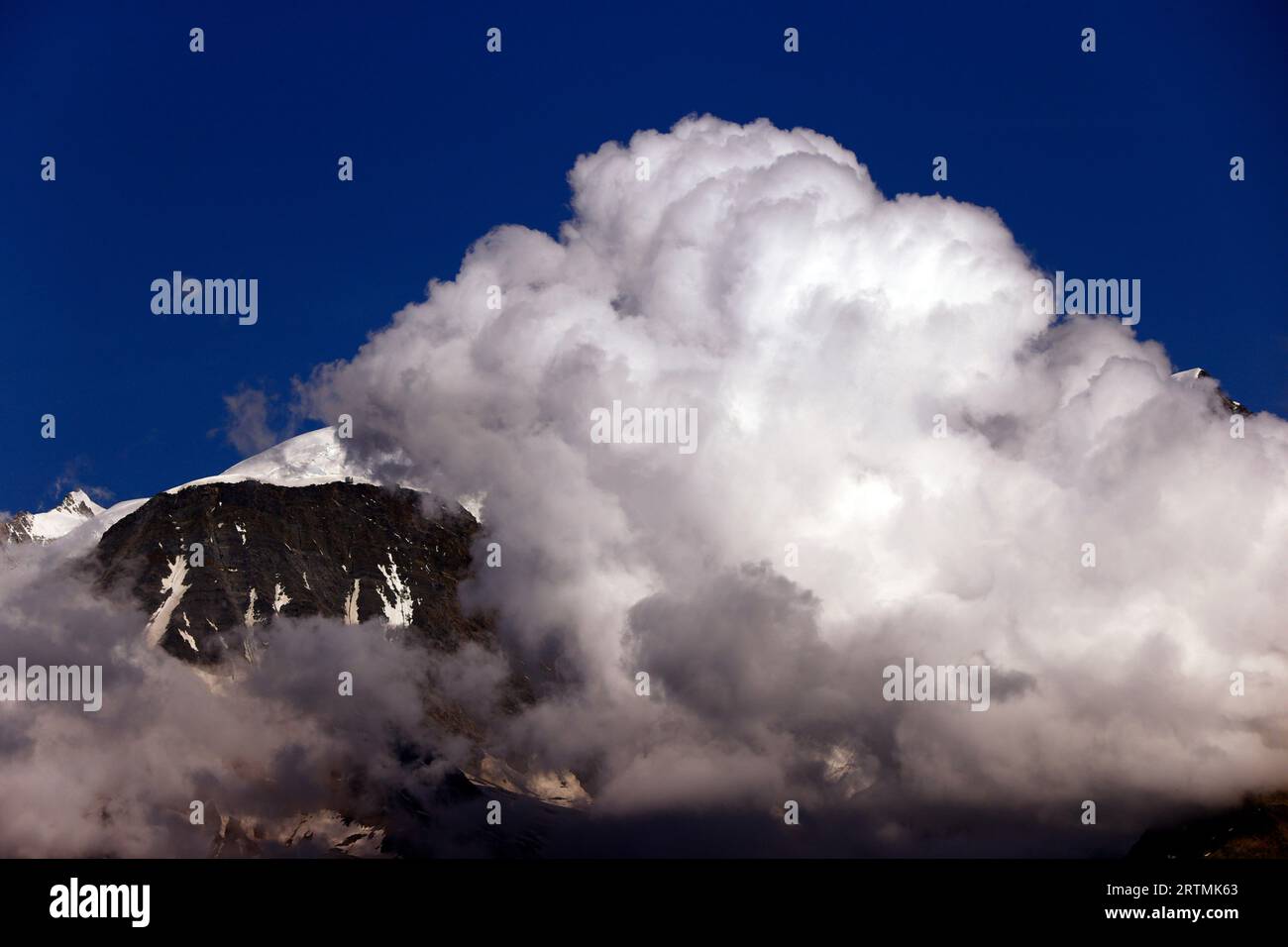 Mont-Blanc massif under a huge white cloud. French Amps. Les Contamines ...