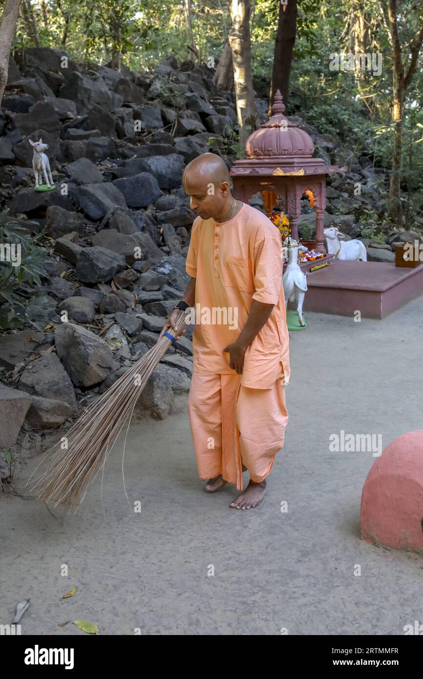 Devotee sweeping a forest temple at Goverdan ecovillage, Maharashtra ...