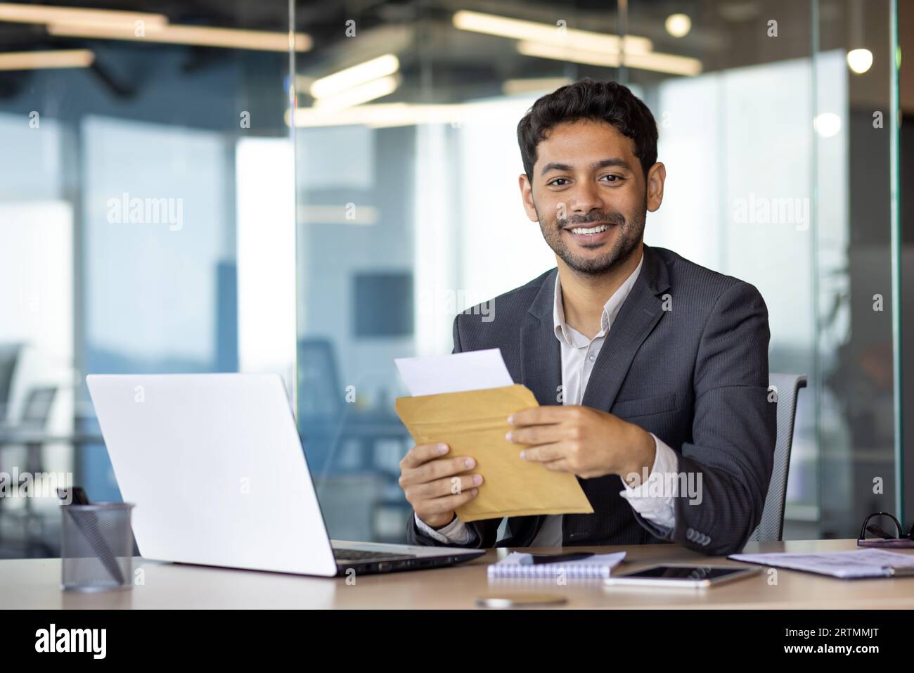 Portrait of young successful businessman at workplace, man received ...