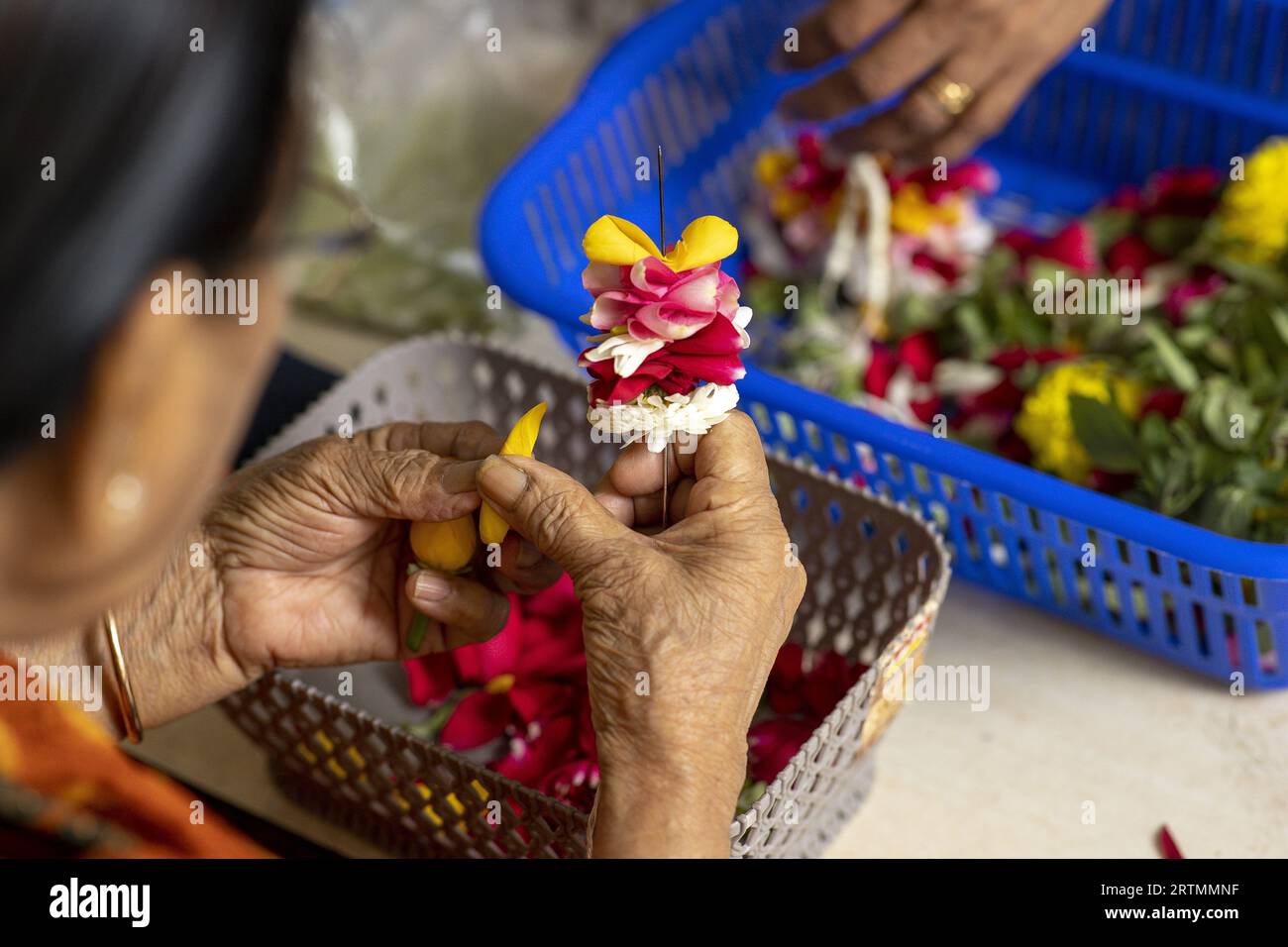 Woman making garlands at ISKCON temple in Juhu, Mumbai, India Stock Photo - Alamy