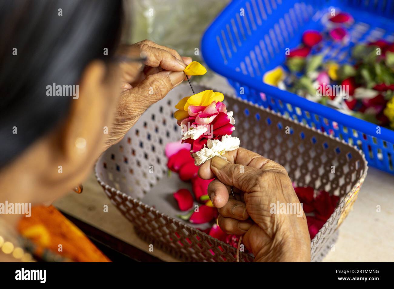 Woman making garlands at ISKCON temple in Juhu, Mumbai, India Stock Photo - Alamy