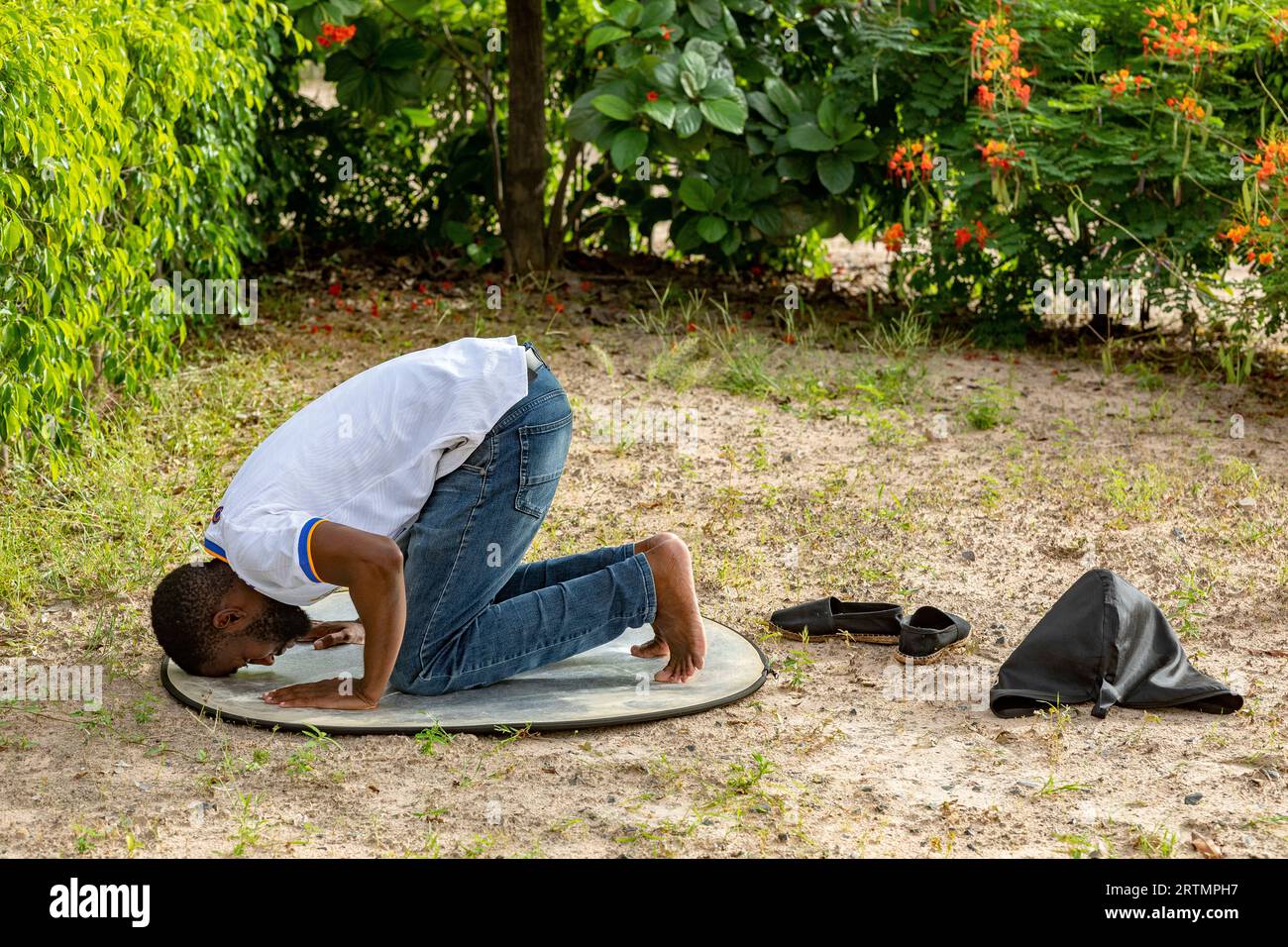 Senegalese photographer using a reflector disk as a prayer mat in ...