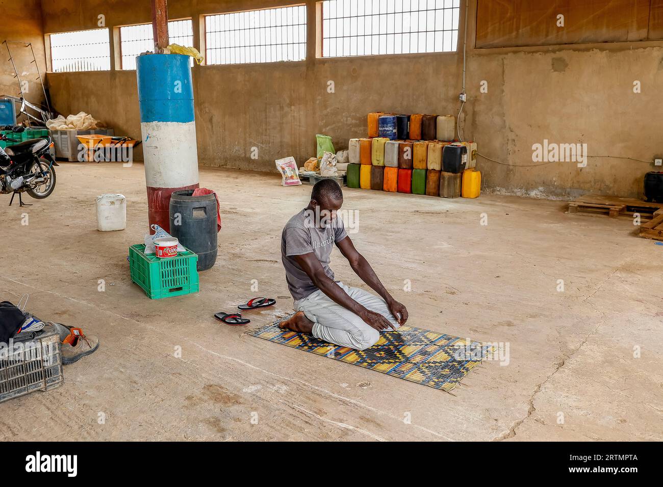 Worker praying in a warehouse in Tawafall, Senegal Stock Photo - Alamy