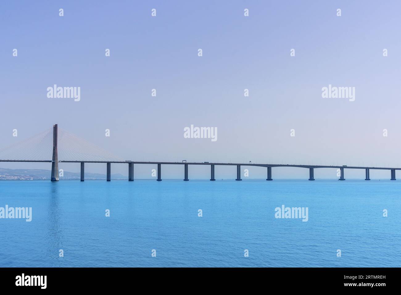 tranquil waterway with calm water and a distant bridge spanning the ...