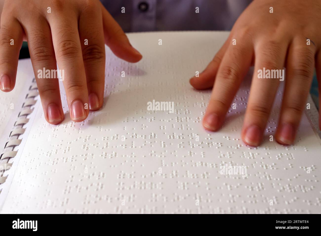 Center for blind children. Blind girl reading braille book Close up on ...