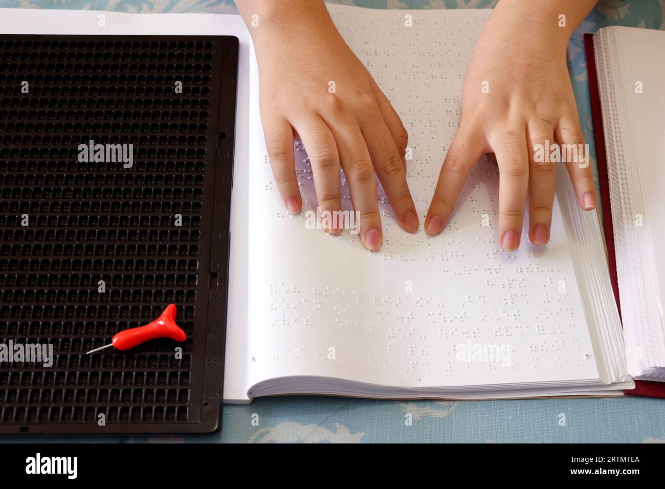 Center for blind children. Blind girl reading braille book Close up on ...